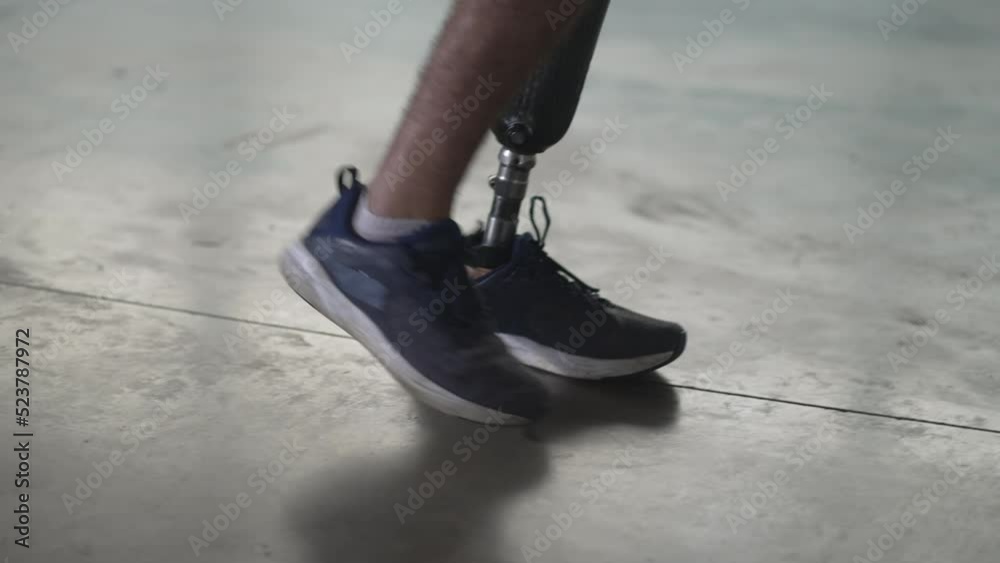 Disabled person walking with his prosthetic leg indoors. Amputee man ...