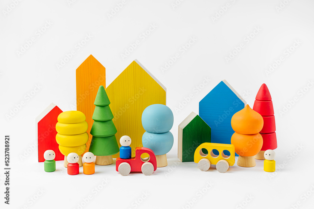Colorful wooden toys. Houses, trees, toy cars and little men in the ...