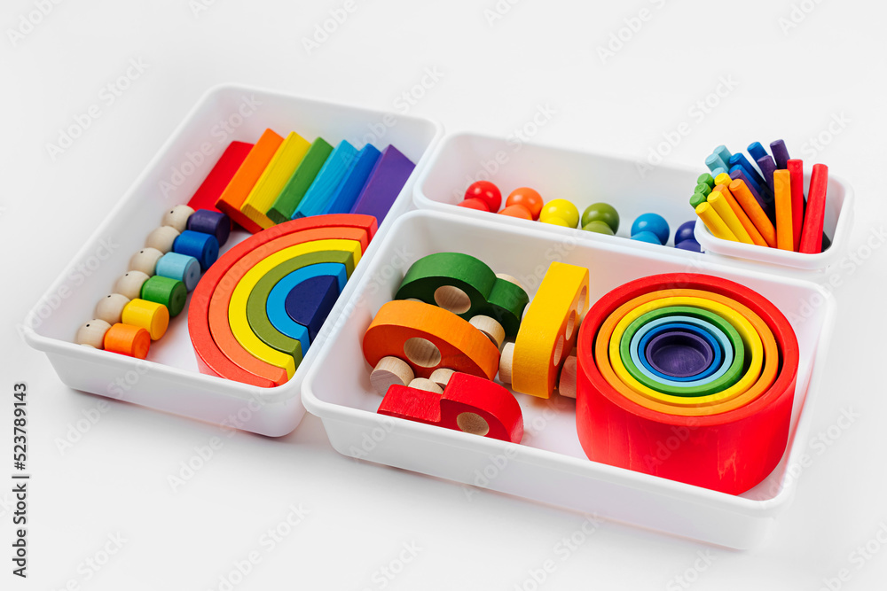 Colorful wooden toys in the colors of the rainbow in plastic box ...