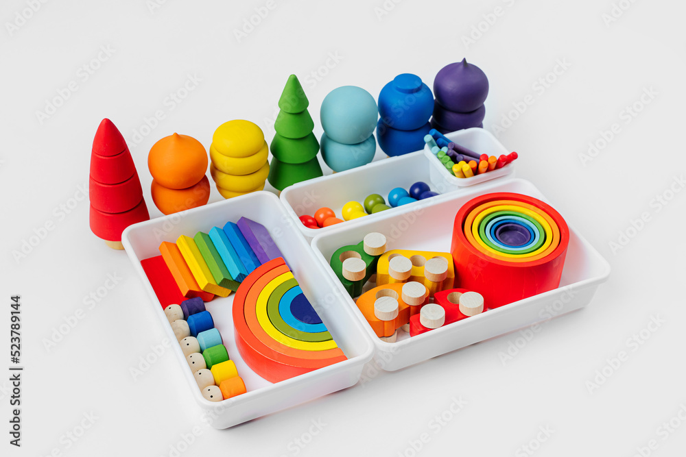 Colorful wooden toys in the colors of the rainbow in plastic box ...