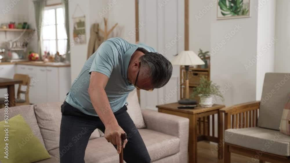 asian injured mature male groaning in pain while he tries to get up ...