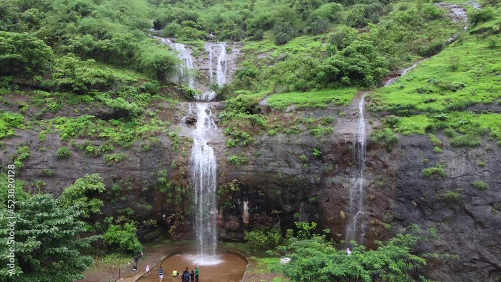 Lush green landscape with waterfalls in full flow during the monsoon ...