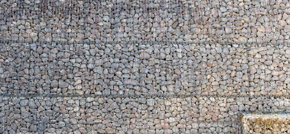 stones in a metal mesh. gray, voluminous, structural broken basalt ...
