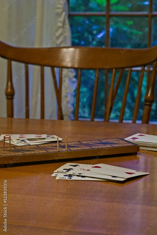 Vintage wooden cribbage board and playing cards set in colonial scene ...