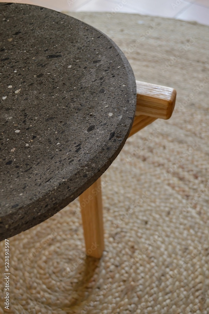 Small side table from a natural stone top, and wooden legs on a round ...
