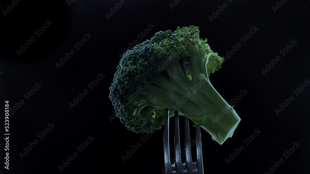 Vidéo Stock Broccoli impaled on a fork rotates on a dark background ...