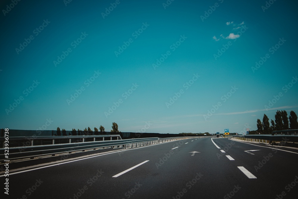 Asphalted road with white markings and railings under a blue sky Stock ...