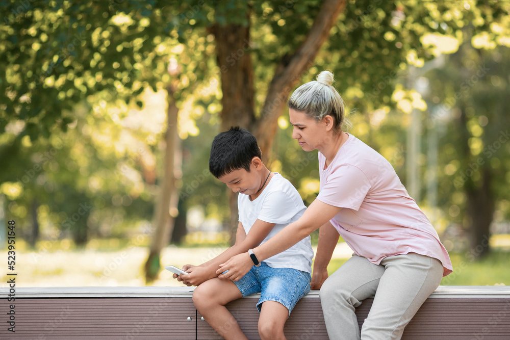 Mother trying to take a mobile phone away from her 10 years old son ...