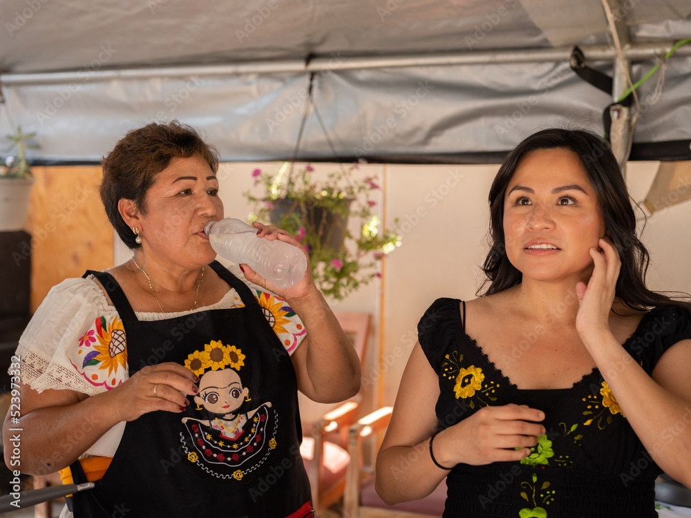 Two frame image of an Indigenous mother drinking water next to her ...