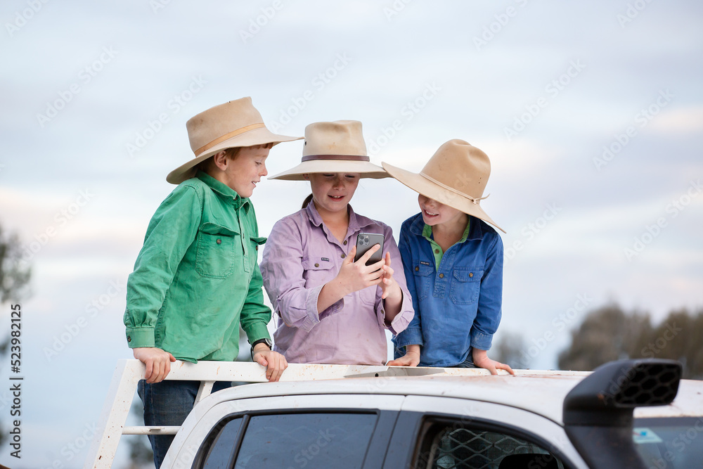 Kids use a phone to take photos on the back of a ute Stock Photo ...