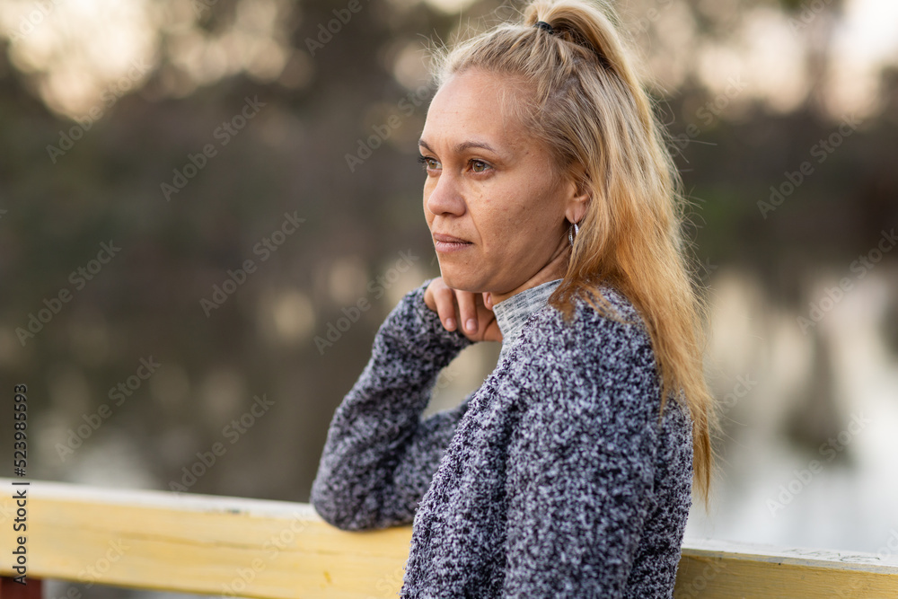 head and shoulders of aboriginal woman with blonde hair side on to ...