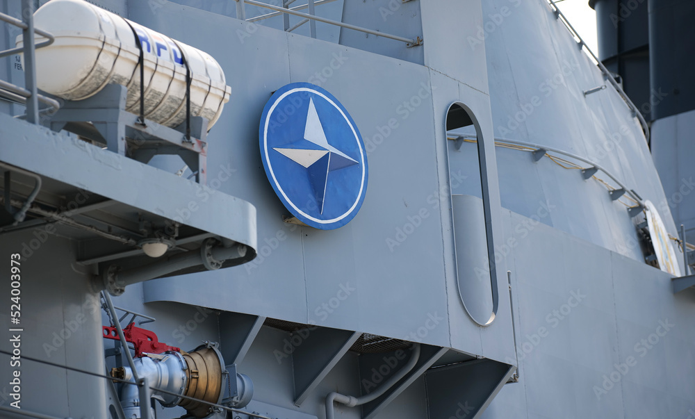 The logo sign of NATO placed on a military vessel ship. North Atlantic ...