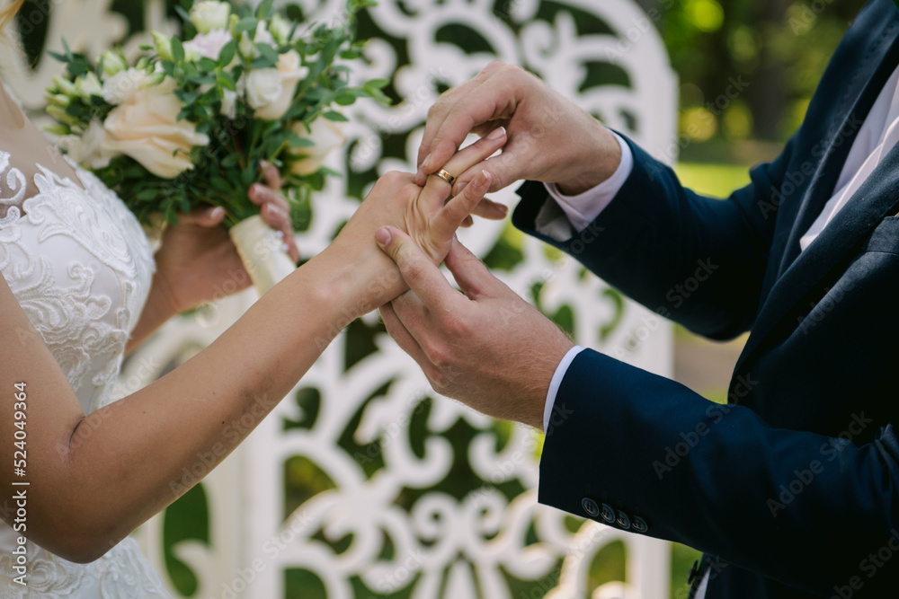 The newlyweds exchange rings, near the wedding arch, at the wedding ...