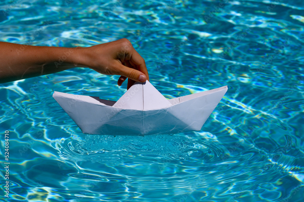 Paper boat sailing on water causing waves and ripples. Tourism and ...