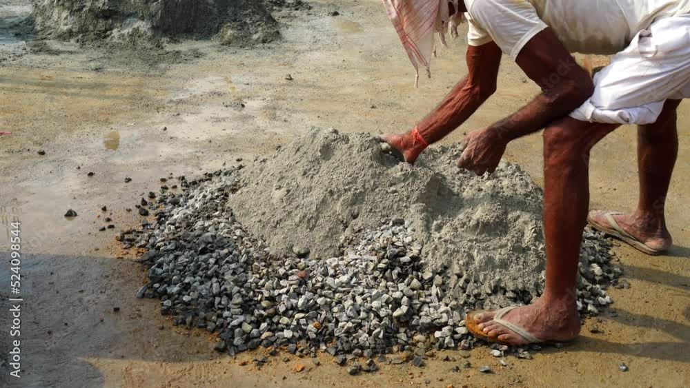 Create a concrete mix in the streets, a male worker mixing sand and ...