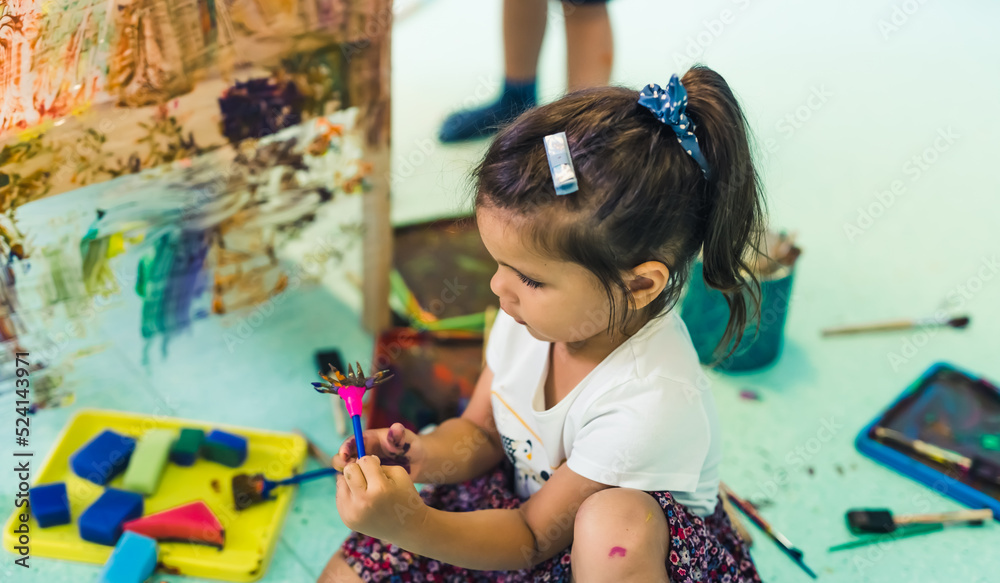 Cling film painting. Little girl toddler painting with a sponge ...