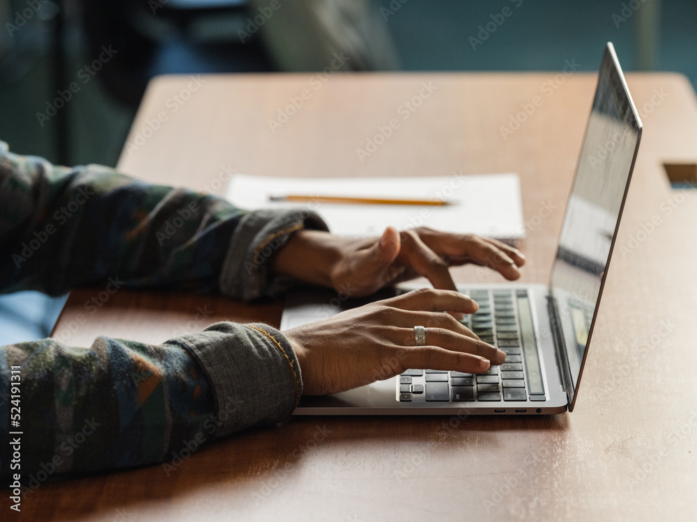 Student using a laptop on their desk in the classroom Stock Photo ...