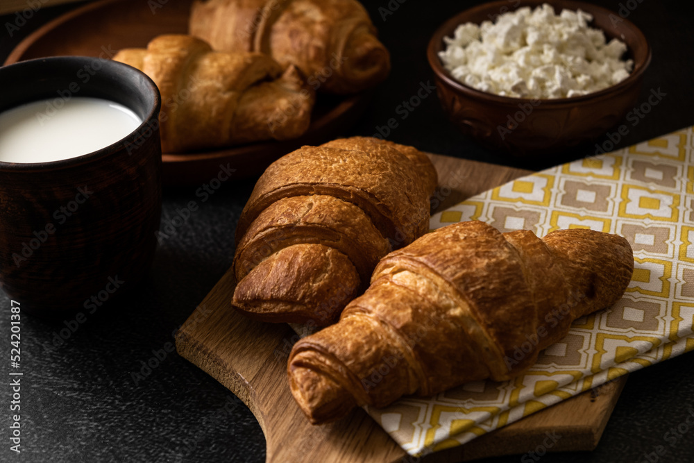 Cozy breakfast with croissants, cottage cheese and milk on a dark ...