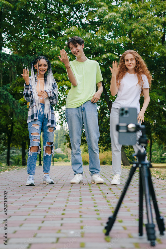 Trendy smiling teenagers vlogger dancing and recording video stream for ...