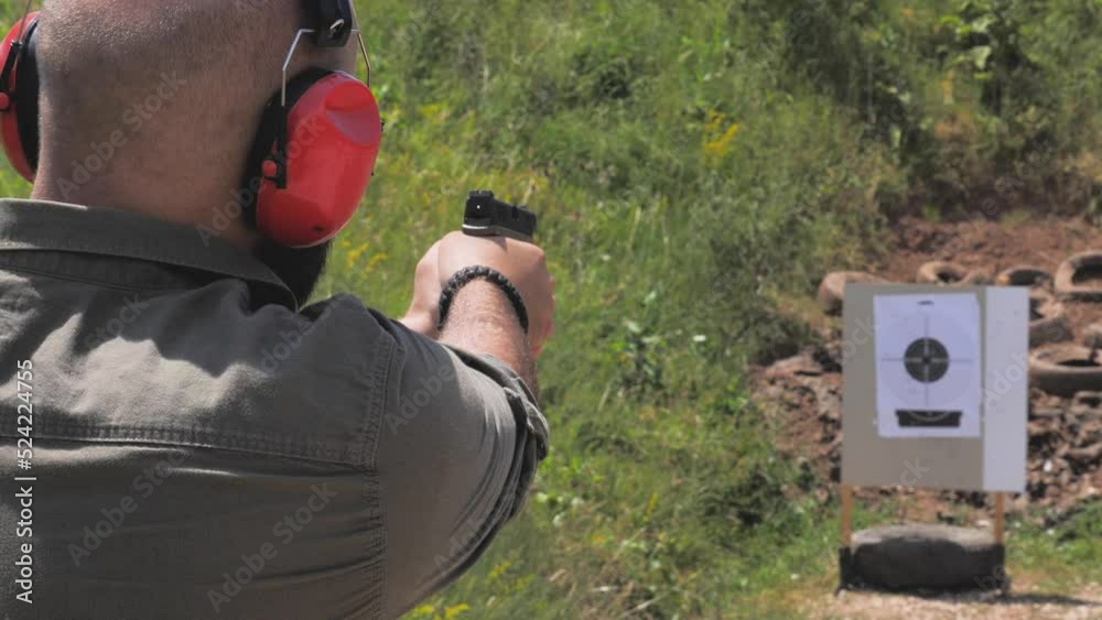 Footage of a man aiming his gun to a target at a training center Stock ...