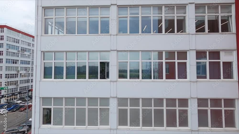 Motion inside modern office building with red facade from city street ...