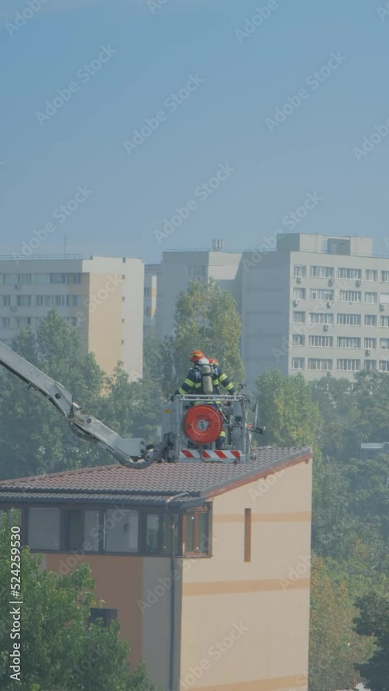 Vertical video: View of firemen using platform truck from fire ...