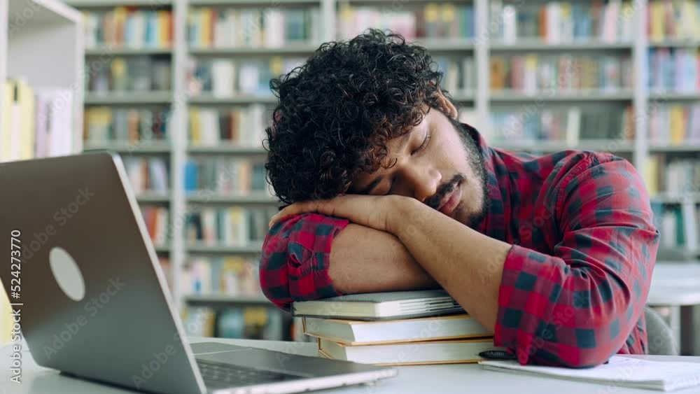 Tired bored arabian or indian university student, is sleeping while ...