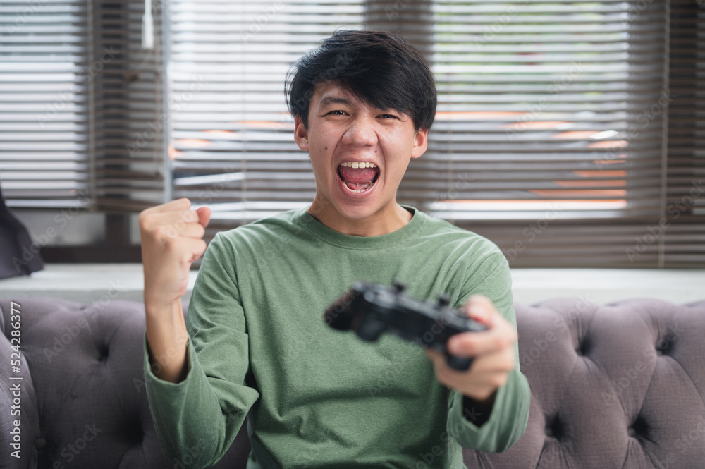 Excited face of Asian gamer or winner gamer holding joystick playing ...