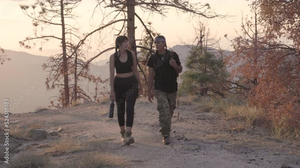 Young Native American hikers walking on a trail during golden hour ...