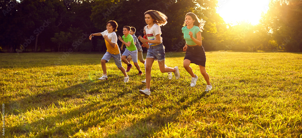Kids playing outside. Happy school children running in sunny park ...