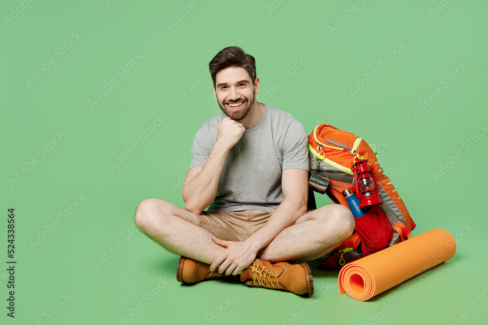 Full body young traveler white man near backpack stuff mat sit take ...