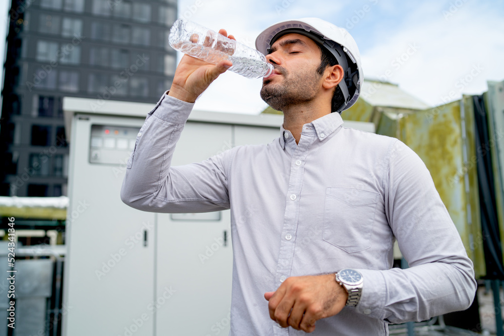 Engineer man or technician worker drink water from bottle and stand in ...