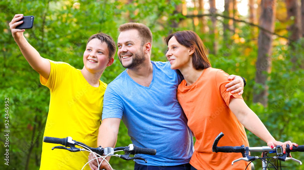 happy family takes a selfie while walking through the forest on ...