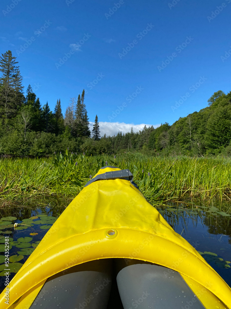 Kayak gonflable sur un lac paisible l'été. Pointe d'un canot jaune sur ...