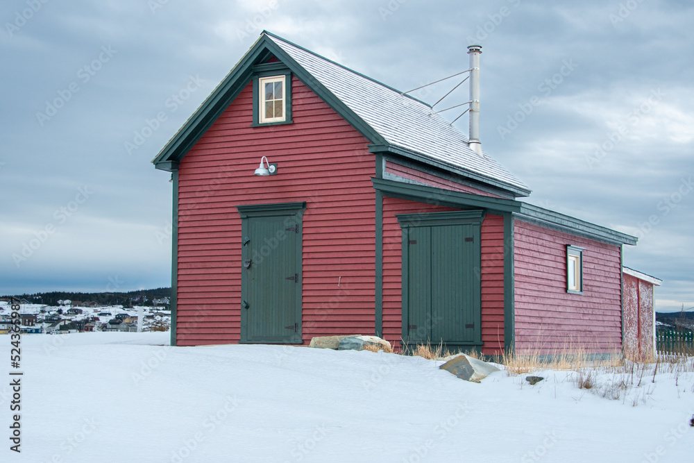 The exterior of an old red wooden building with a peaked cedar shake ...