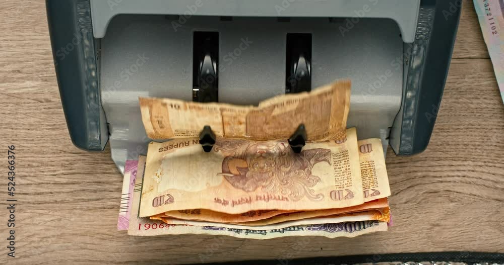 Top view of cash money counting machine calculating many Indian paper ...
