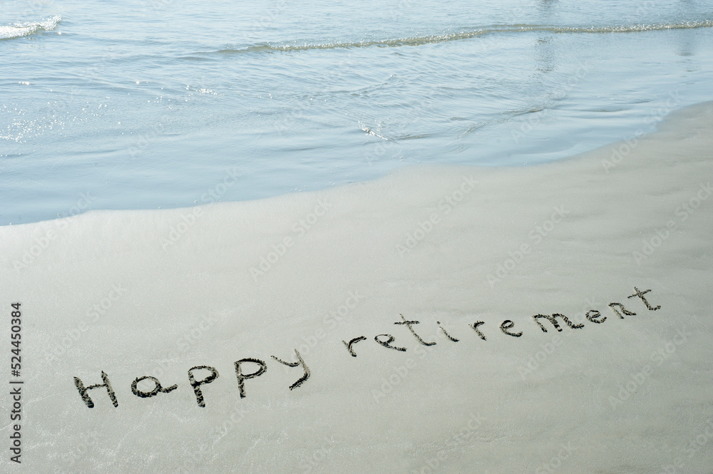 Concept or conceptual HAPPY RETIREMENT handwritten text in sand on a ...
