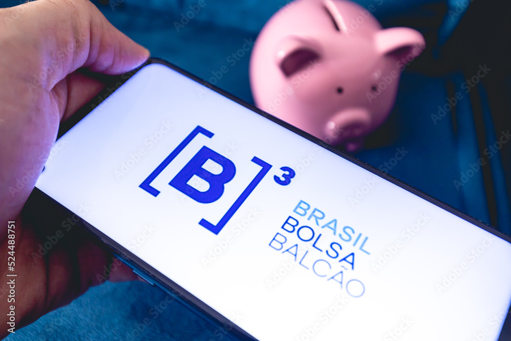 B3 - Bolsa de Valores brasileira. Um homem segurando um celular na mão ...