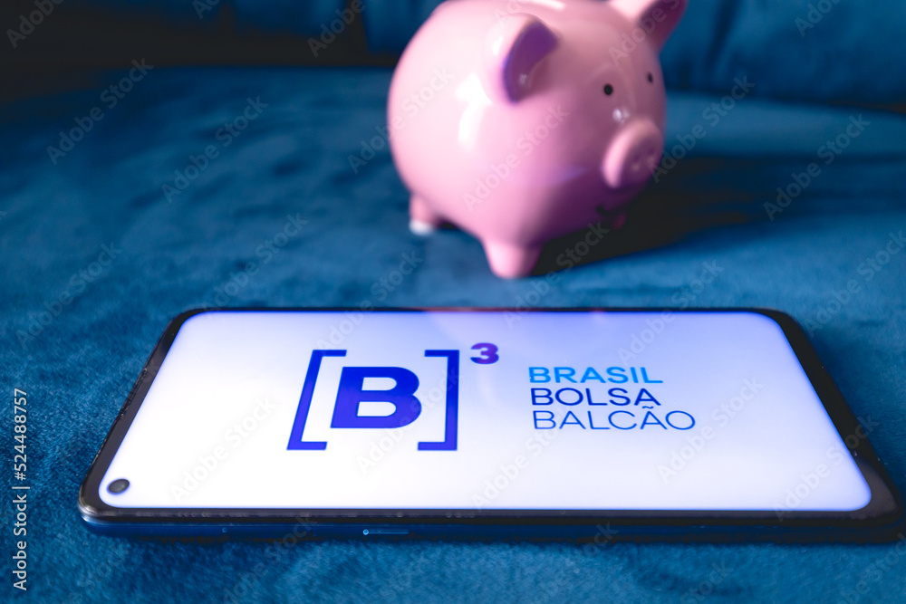 B3 - Bolsa de Valores brasileira. Um homem segurando um celular na mão ...