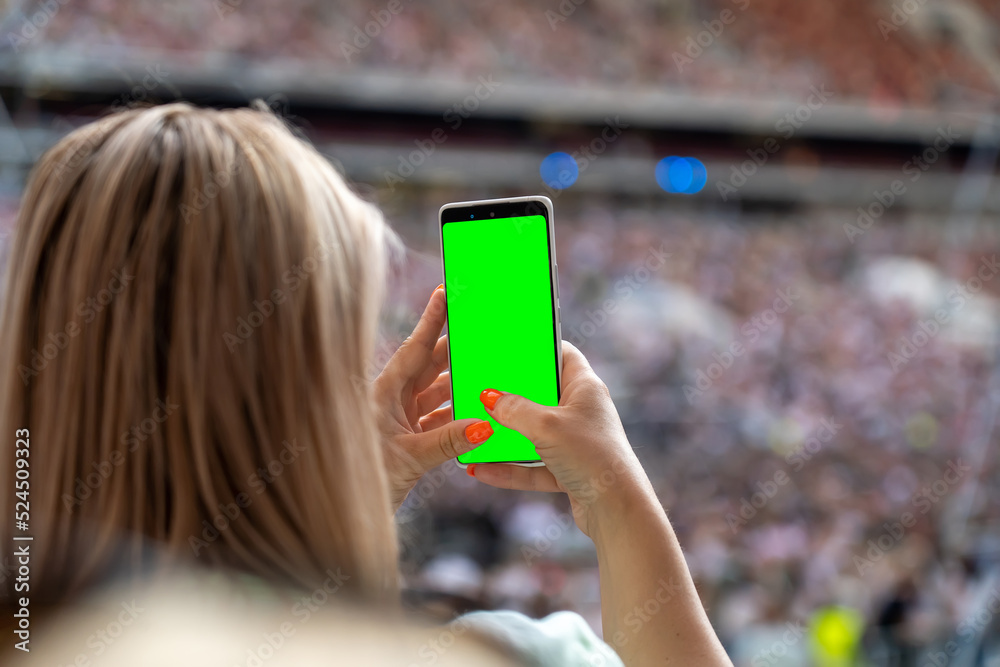 Foto de Woman records vertical green screen video with mobile smart ...