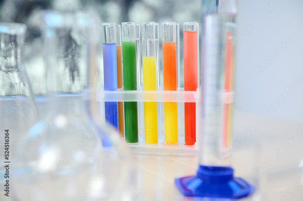 Focus on test tubes with rainbow colored chemicals and reagents ...