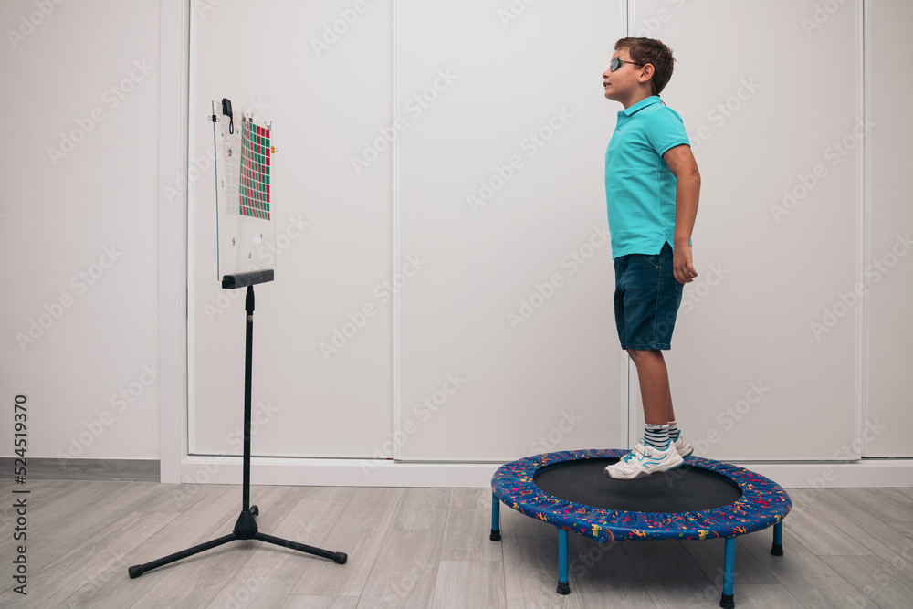 A child undergoes vision therapy with hart cards while bouncing on a ...