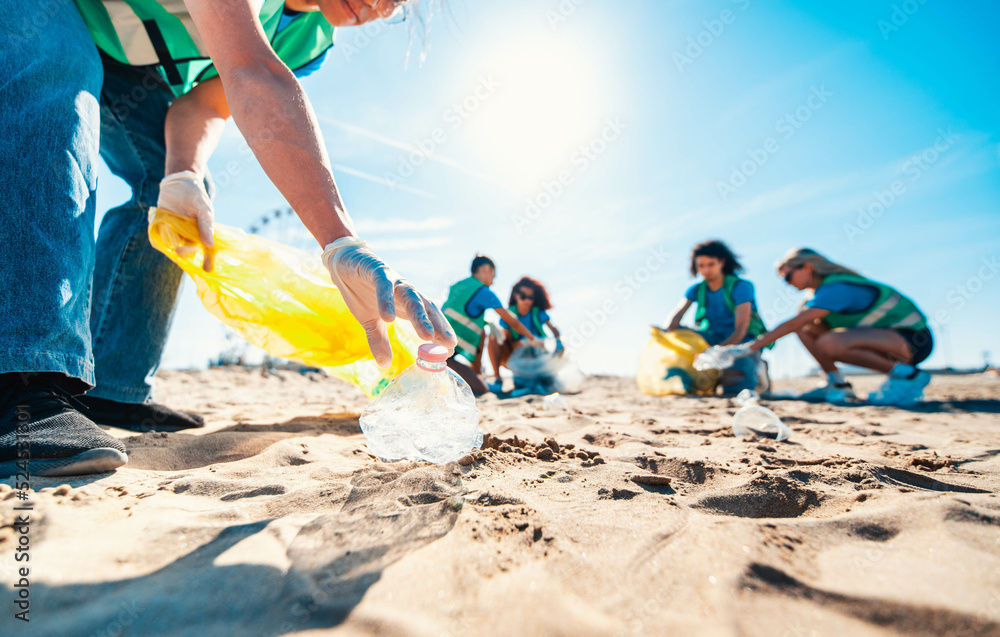 Group of eco volunteers picking up plastic trash on the beach ...