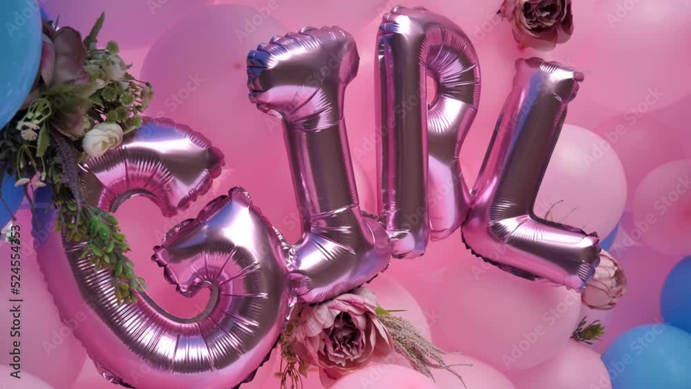 Letters from pink helium balloons forming the word Girl during a gender ...