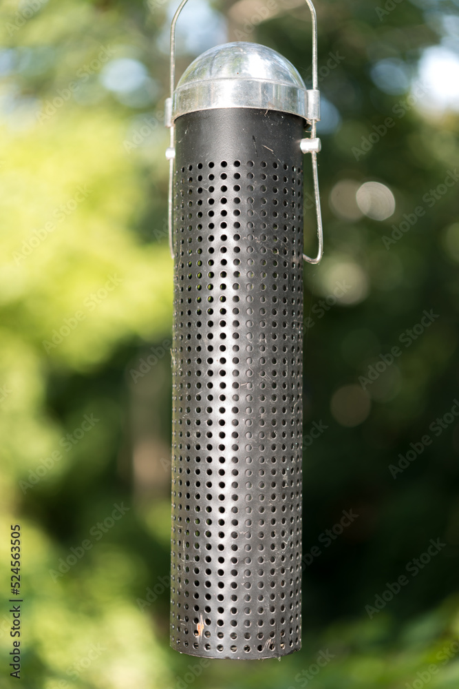 canister with tiny holes and cone lid with handle hanging from tree ...
