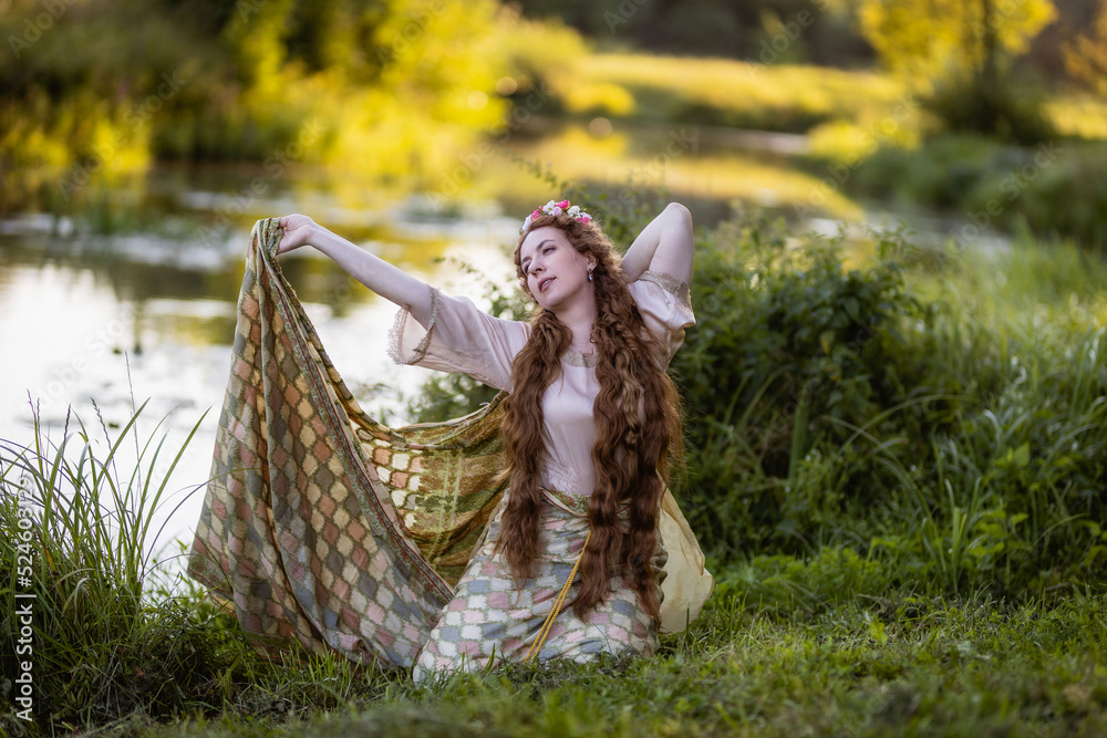 Portrait of a beautiful mature woman dressed in a nymph-style dress ...