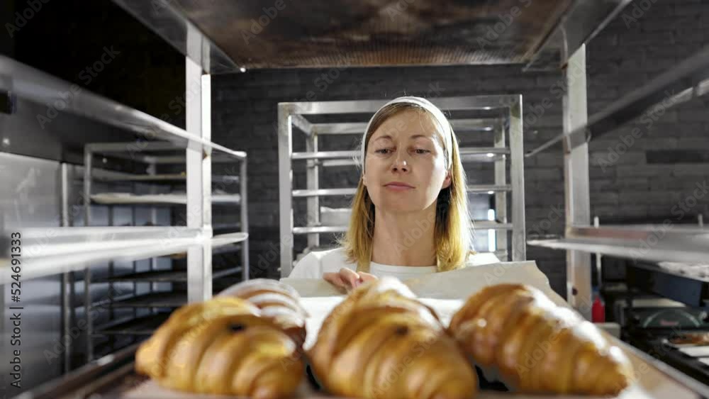 Caucasian beautiful woman in hat and uniform working in bakehouse and ...
