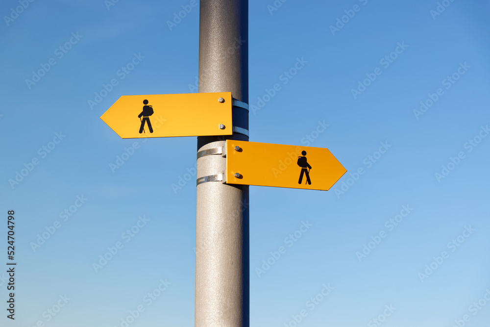 two yellow hiking trail signs with symbol person, backpack, hiking ...