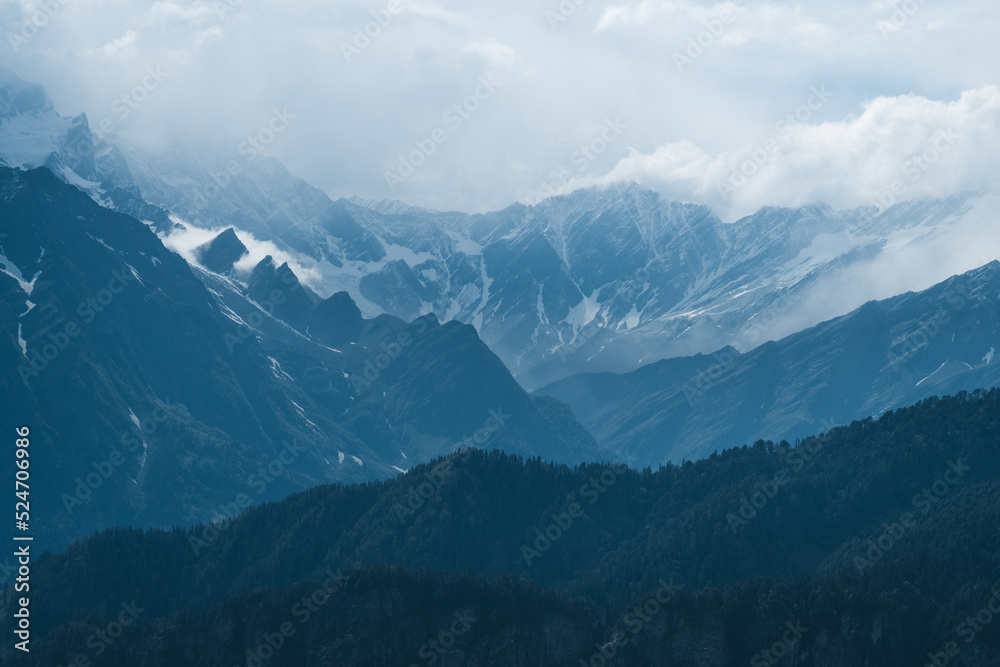Snow covered Himalayan mountain range with clouds rolling over peaks ...