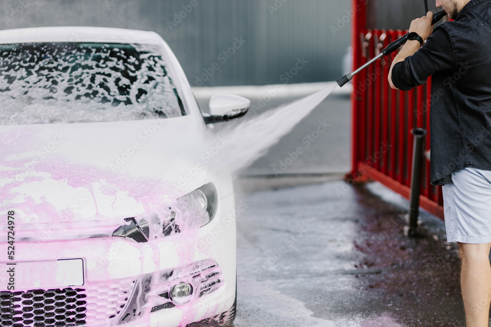 Man washing white car at contactless self-service car wash. Washing ...